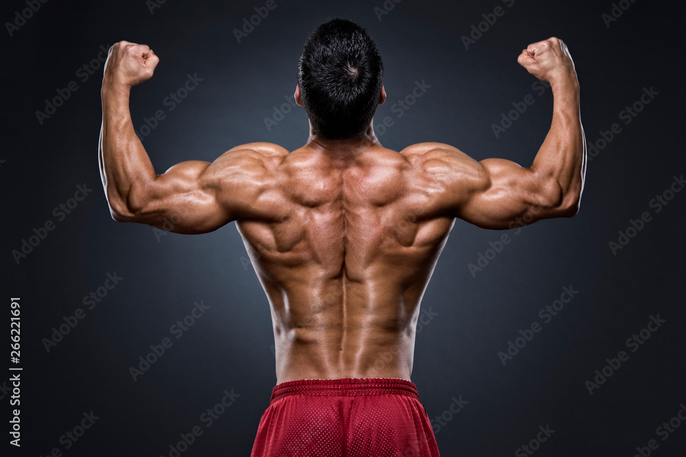 Strong Muscular Men Flexing Muscles from the Back. He is showing back ...