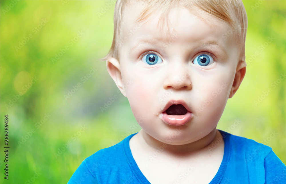 Happy surprised toddler with his blue eyes and mouth open isolated ...