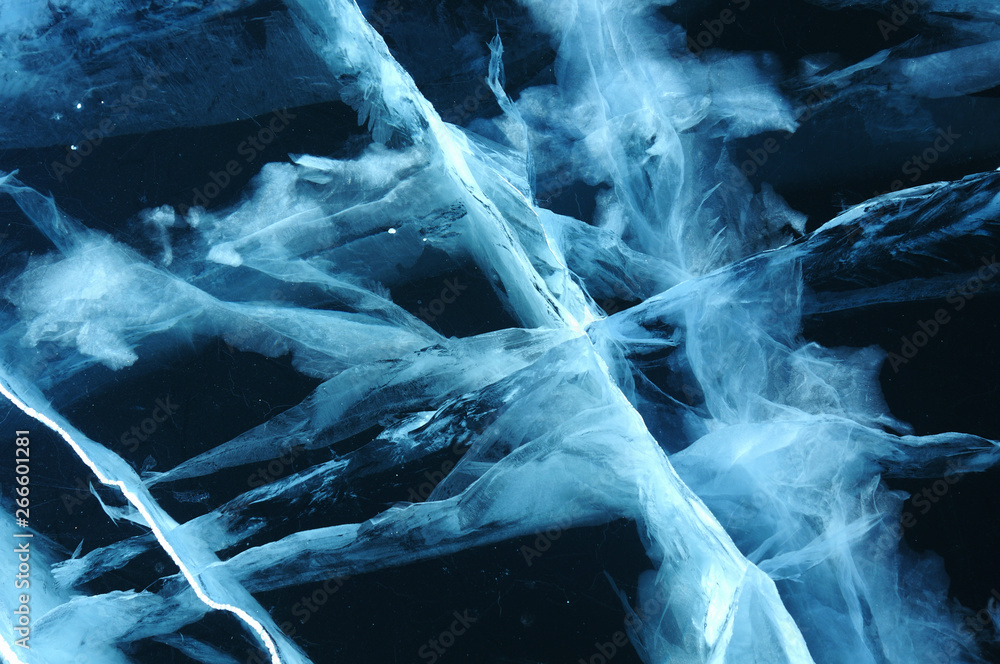 Sun rays are refracted by the transparent ice of Lake Baikal. cracks at ...