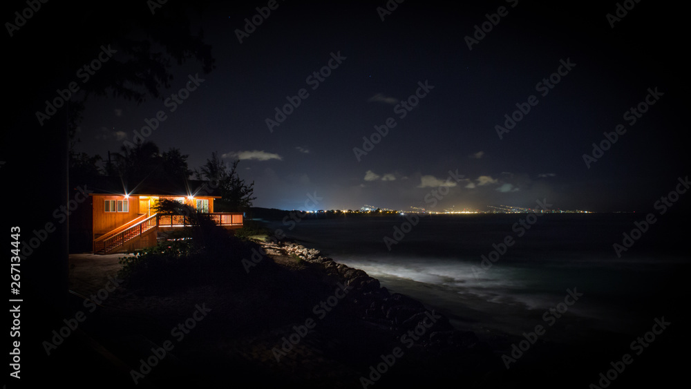 Solitary Cabin on the Beach at Night - with City Lights on the Horizon ...