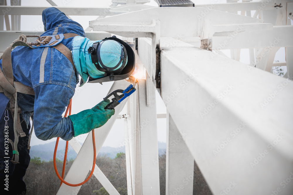 Industrial welder welding fabricated metal truss structure assembly on ...