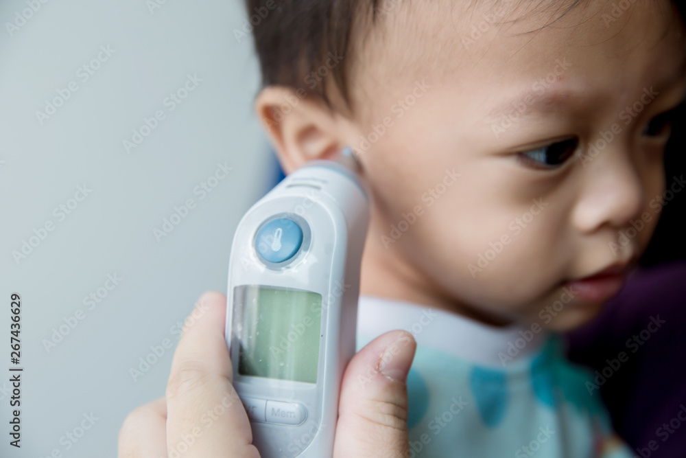 Doctor measuring temperature cute baby boy at hospital . Mother takes ...