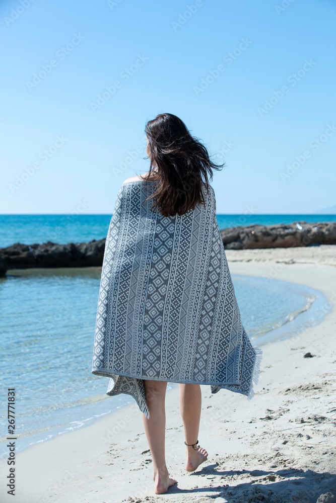 Pretty young girl wrapped in beach towel poses to camera. Full length ...