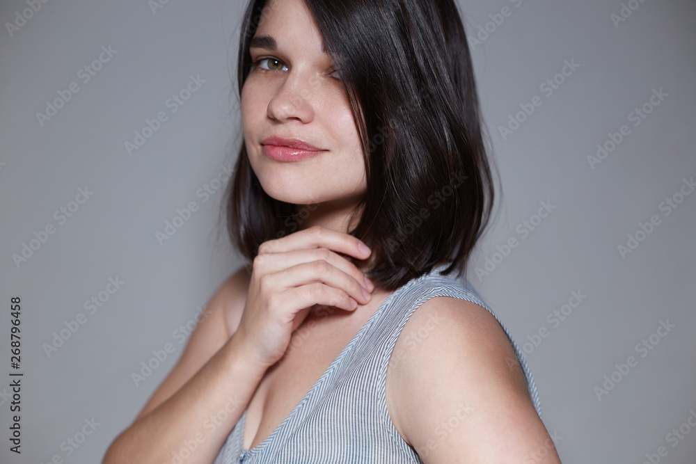 lovely beautiful young girl pulls a strand of hair, she looks at the ...