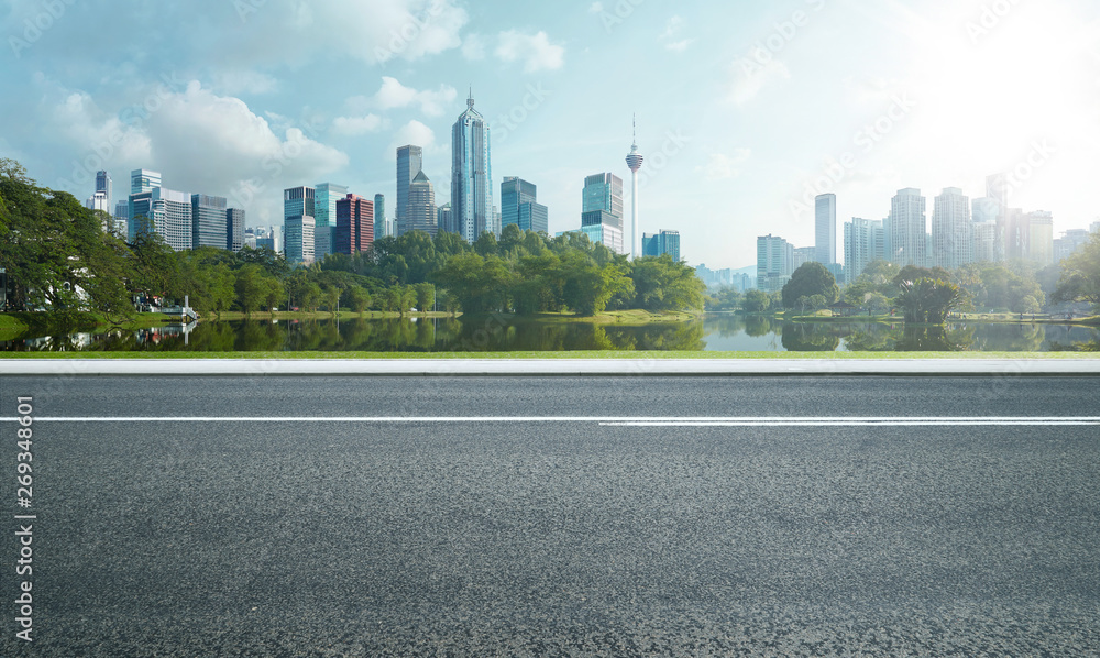 Side view of asphalt road highway with lake garden and modern city ...