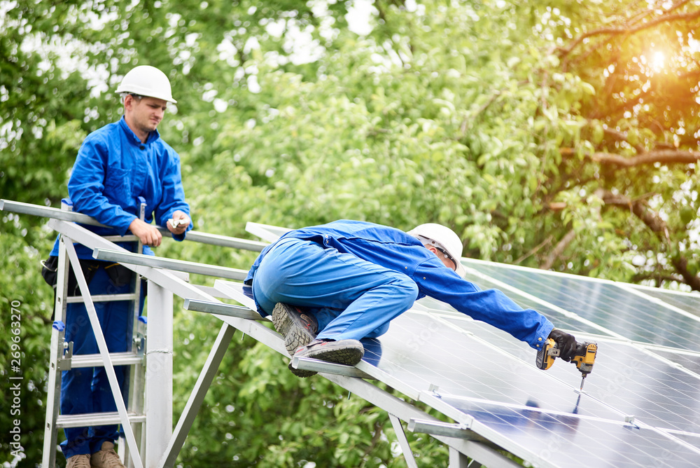 Team of two constructors connecting photo voltaic panel to stand-alone ...