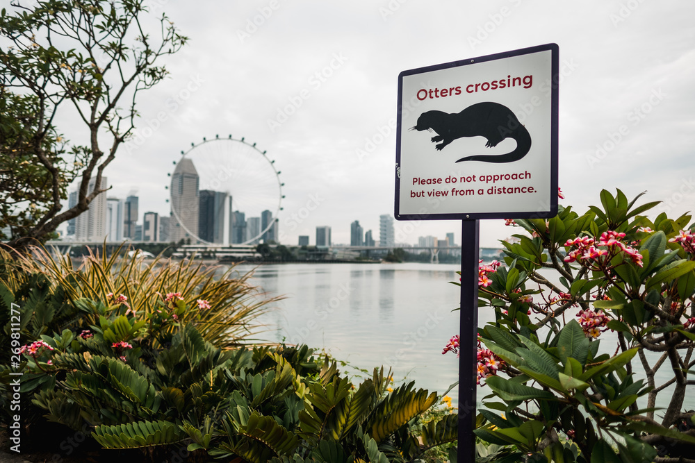 Singapore: Otter crossing sign in front of the river, view on downtown ...