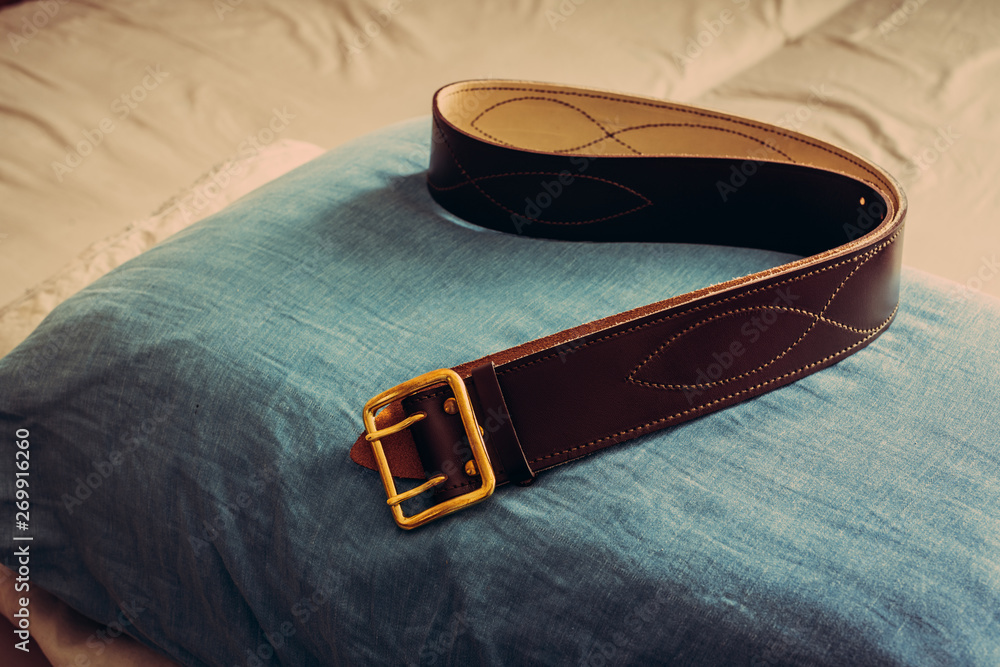 Foto de Stock leather belt on the bed prepared for spanking. domestic ...