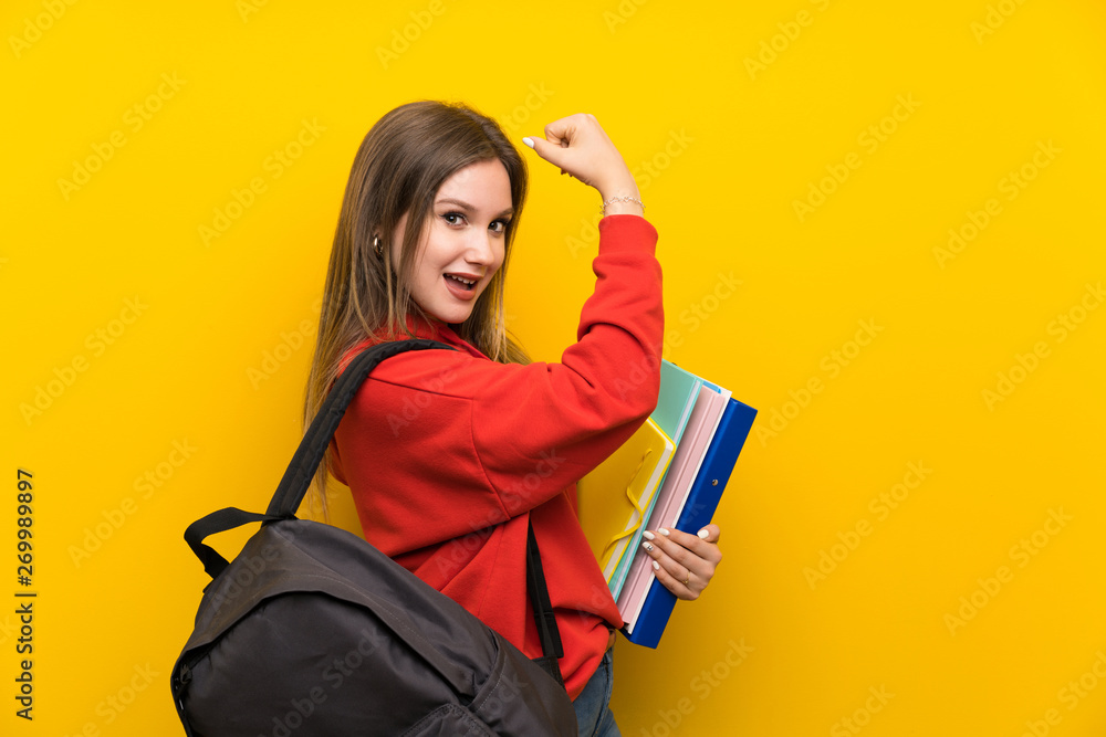 Teenager student girl over yellow background making strong gesture ...