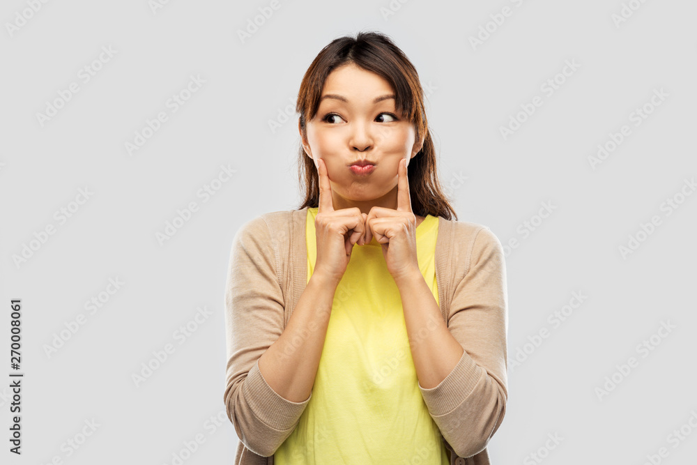 people, emotions and expression concept - young asian woman making ...