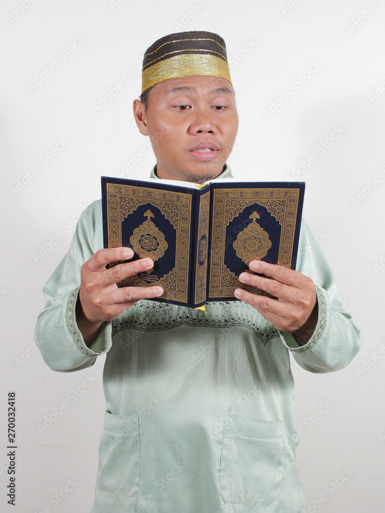 Asian Muslim men read the Holy Qur'an by wearing Muslim clothes and ...