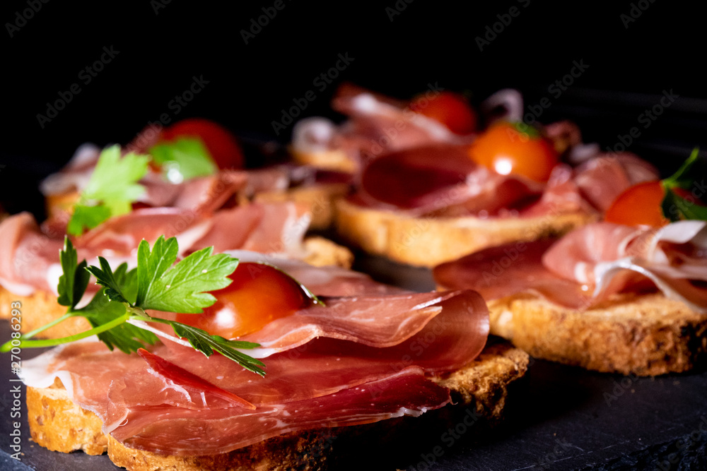 jamón serrano sobre pan tostado con tomate cherry y perejil, en clave ...
