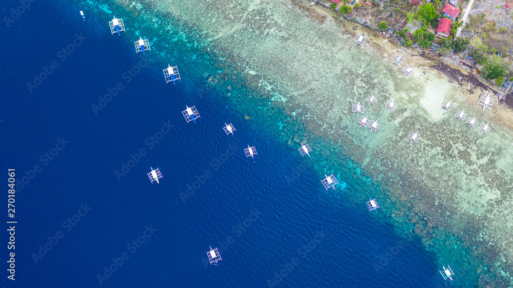 Aerial view of Filipino boats floating on top of clear blue waters ...