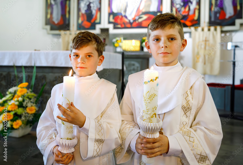 Two little kids boys receiving his first holy communion. Happy children ...