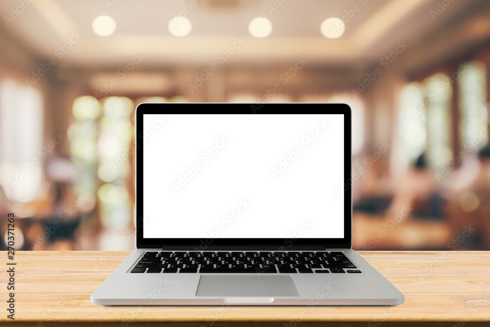 Blank screen laptop computer on wood table top with blur cafe ...