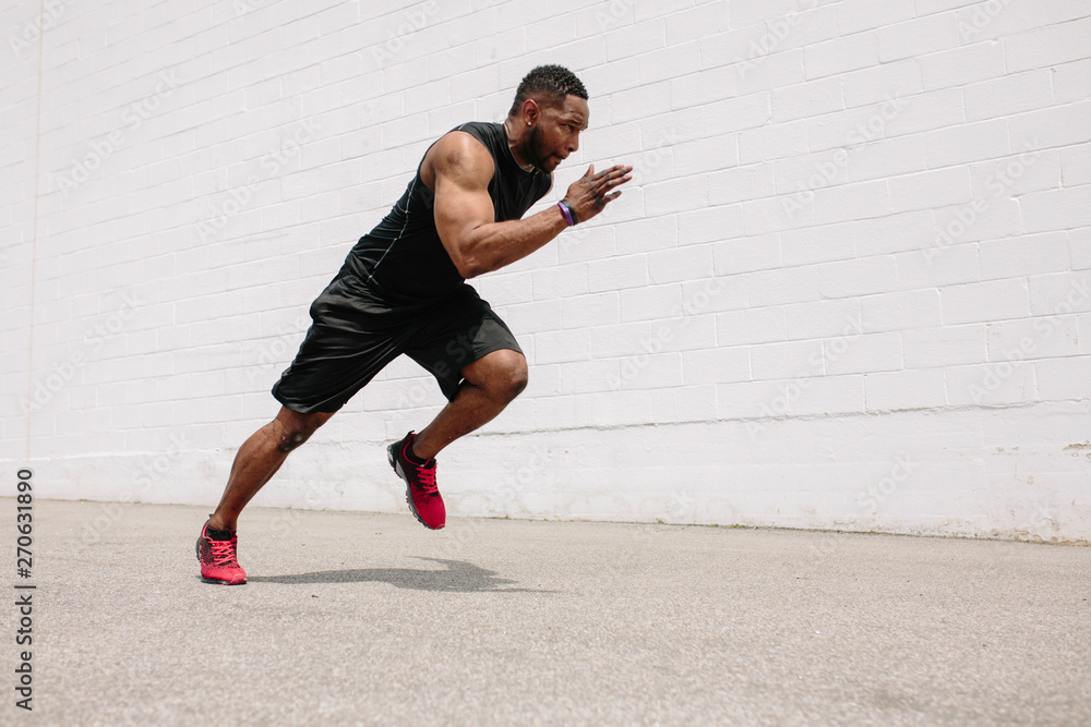 Fit athlete practicing sprints and jumps in a parking lot Stock Photo ...