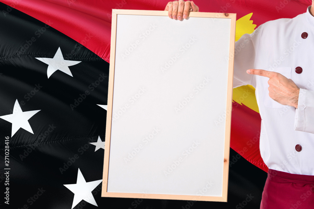 Chef holding blank whiteboard menu on Papua New Guinea flag background ...