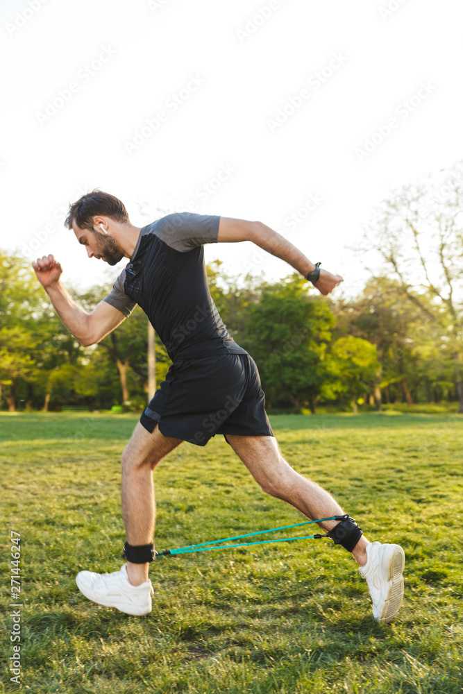 Handsome young strong sports man posing outdoors at the nature park ...