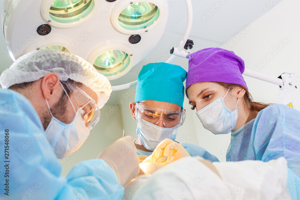 Baldness treatment. Hair transplant. Surgeons in the operating room ...