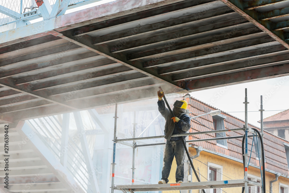 Sand blasting process Industial worker using sand blasting process ...