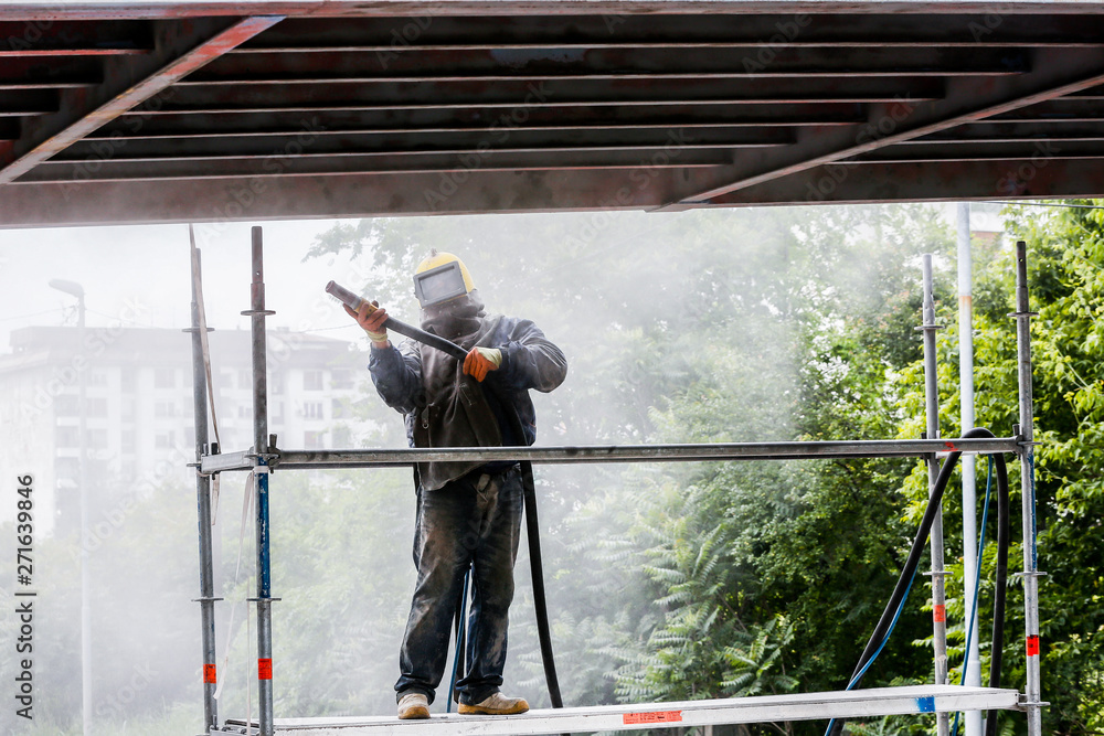 Sand blasting process Industial worker using sand blasting process ...