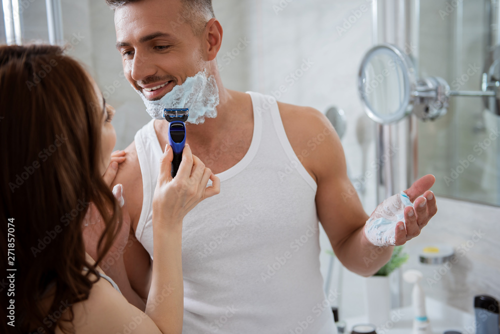 Caring wife helping her husband and shaving his beard Stock Photo ...