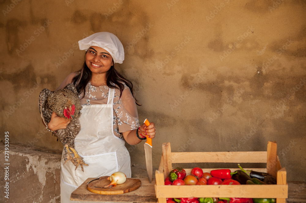 Attractive Indian woman cook posing in kitchen with chicken in her ...