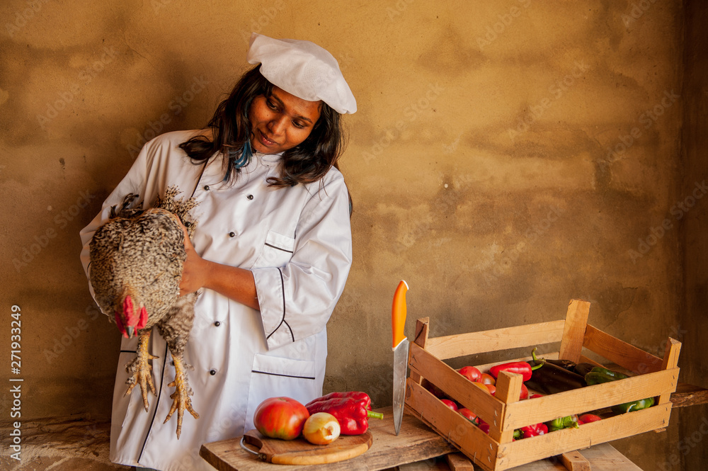 Attractive Indian woman cook posing in kitchen with chicken in her ...