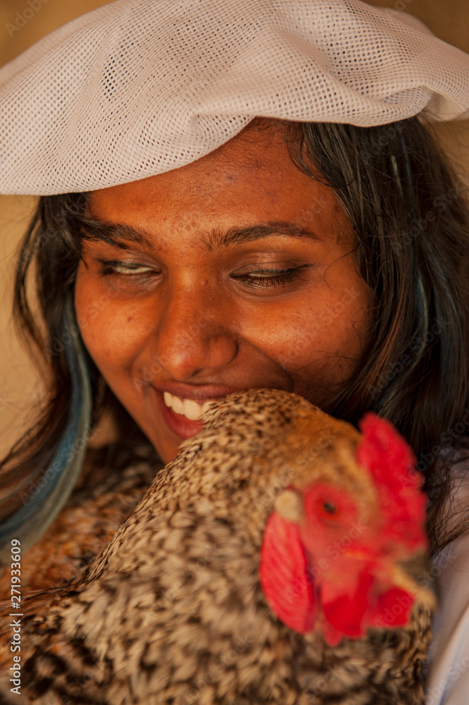 Attractive Indian woman cook posing in kitchen with chicken in her ...