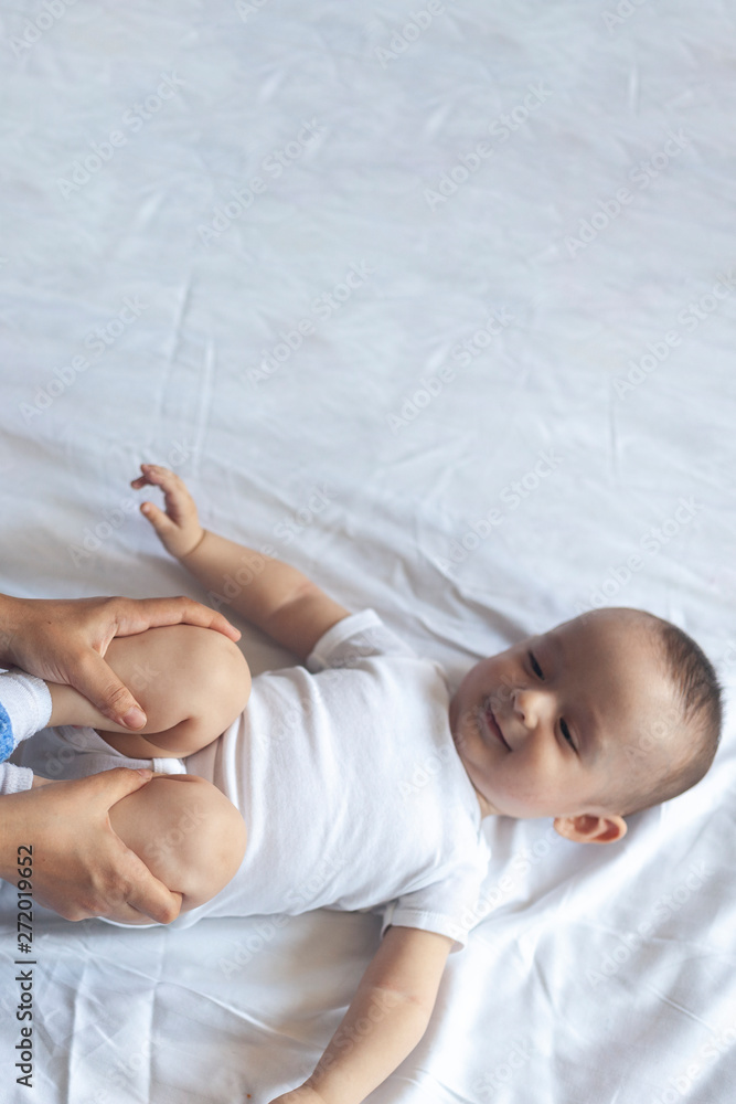Baby massage. Mom doing gymnastics with kid. Mommy massaging cute baby ...