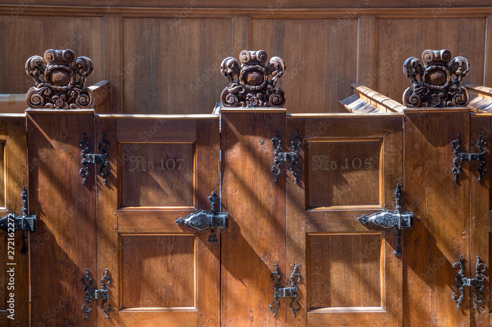 Box pews in a church illuminated by sun. Natural wood texture on hinged ...