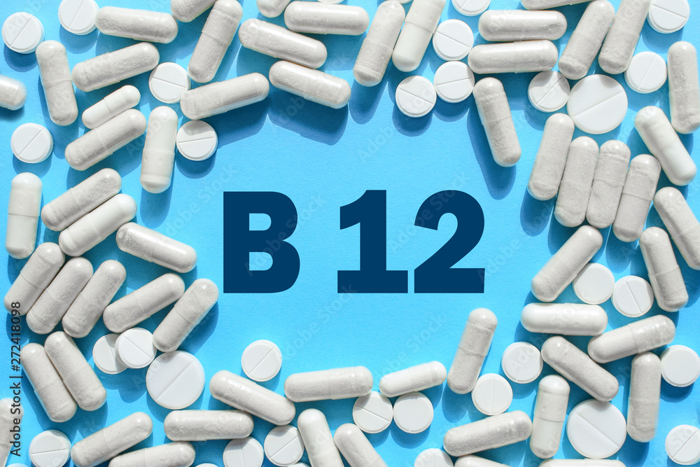 Vitamin B12 text in white capsules frame on blue background. Pill with ...