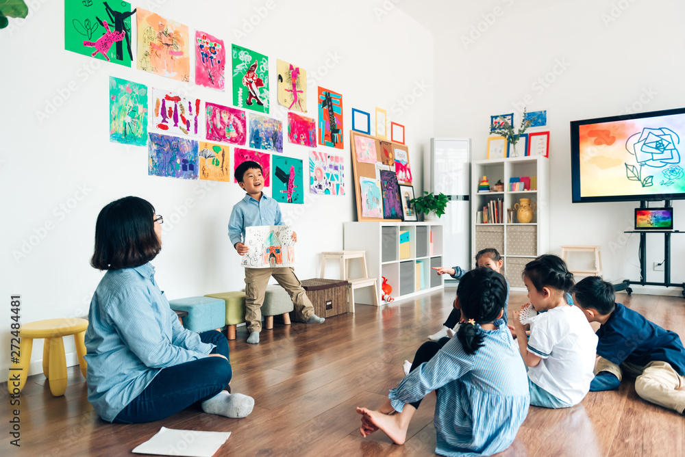 Preshool kid showing drawing to class Stock Photo | Adobe Stock