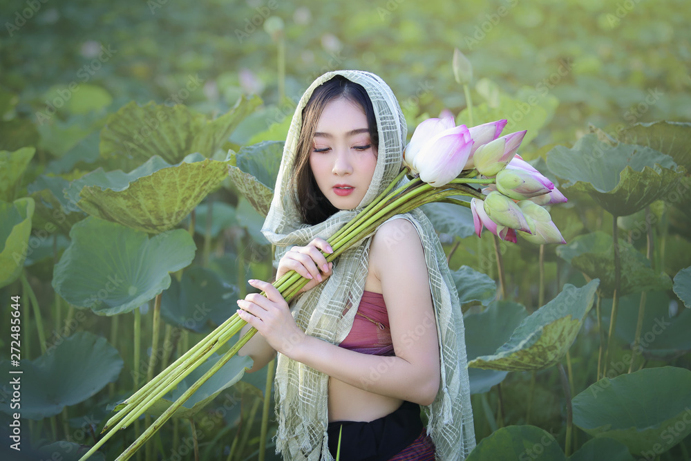 A beautiful woman wearing a traditional dress with a lotus flower, a ...