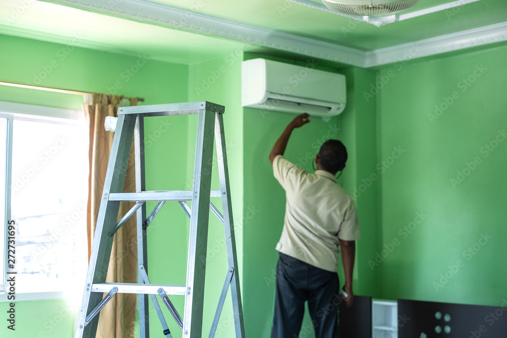 Workers repairs and cleans the air conditioner in the room. Steel ...