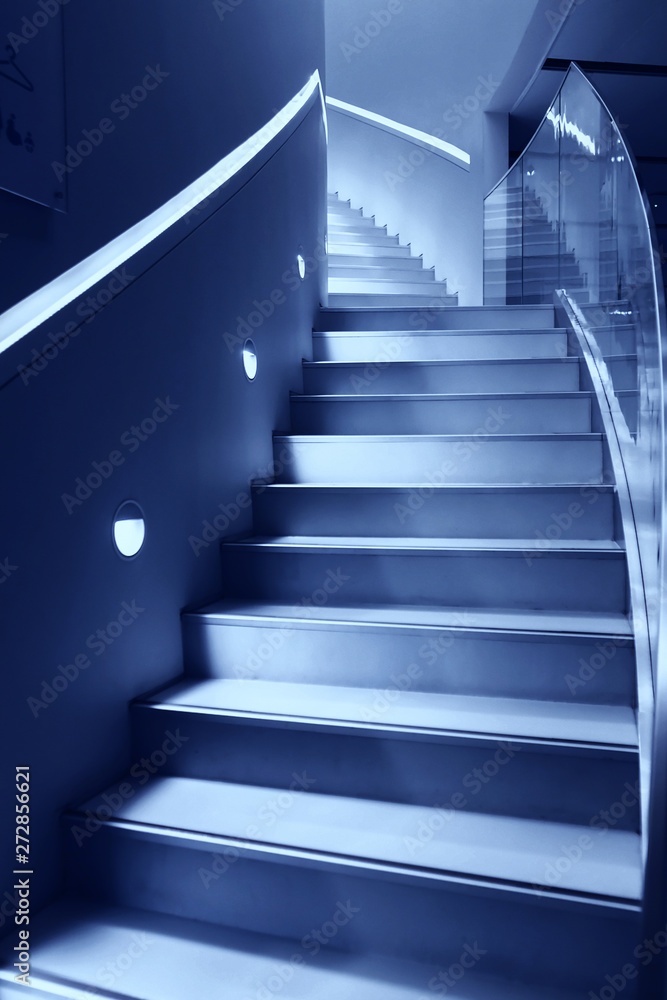 Modern dark blue stairs moving up and light shining handrail with ...