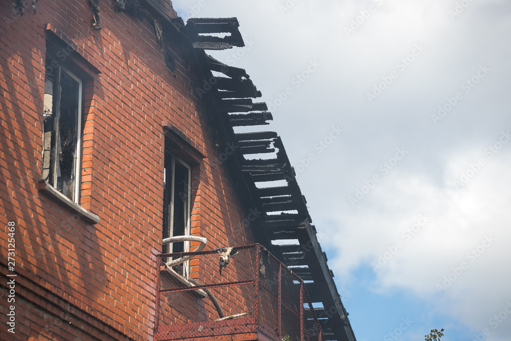 Foto de Stock Smoldering remains of a ghetto house with a fireman ...