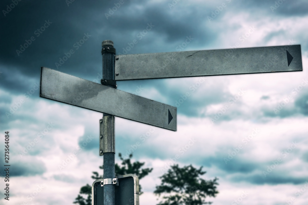 Blank directional road signs. Black metal arrows on the signpost. Warm ...