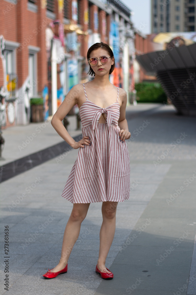 Asian Chinese model girl influencer street shot. Wearing pink dress and ...