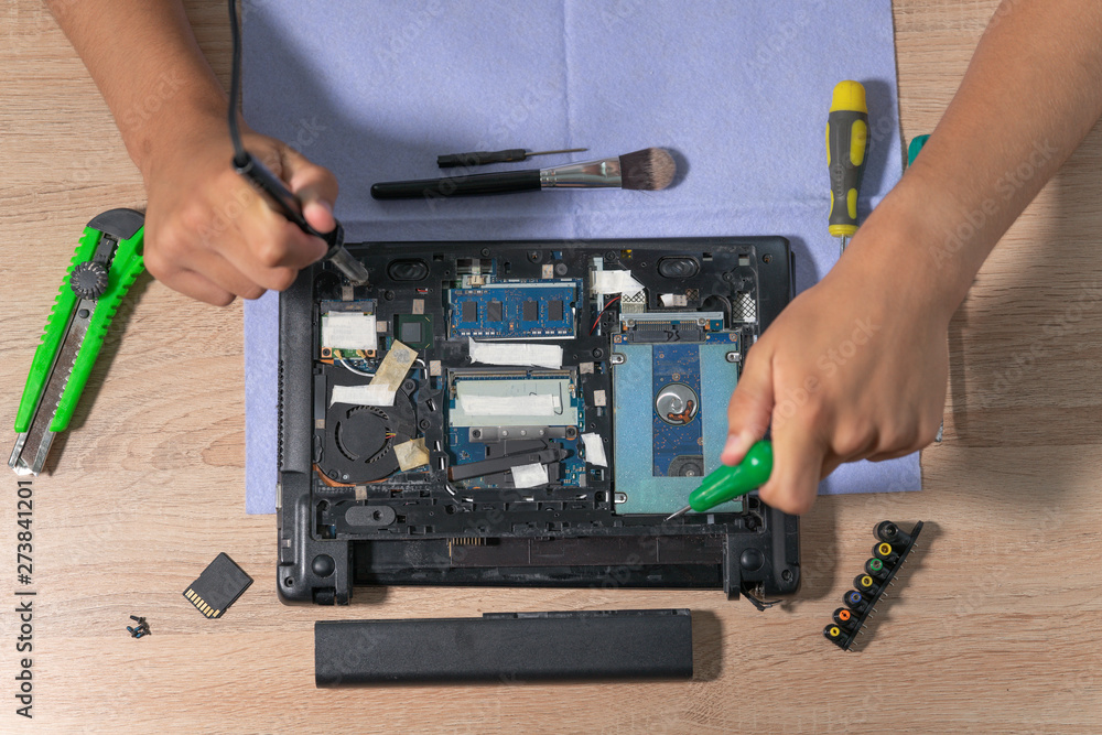 Engineer fixing broken computer at work. Electronic repair shop ...