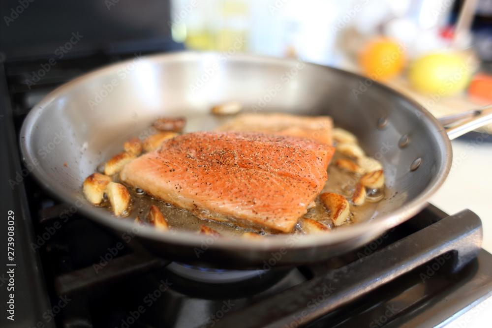 Steelhead frying in a stainless steel pan with the skin side down ...