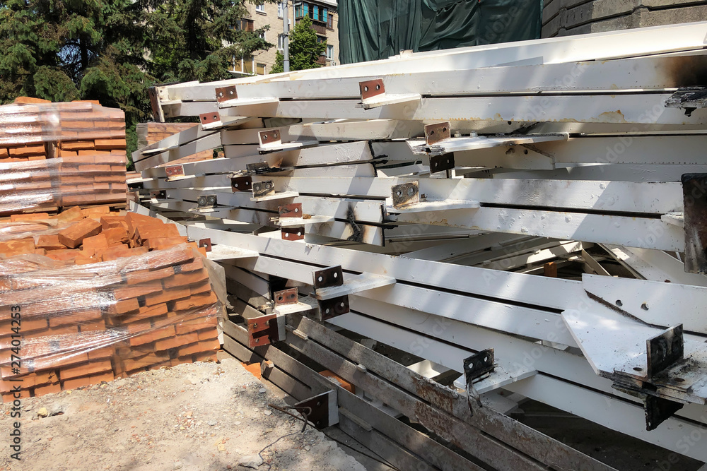 heap of welded iron girders and packs of bricks near the construction ...