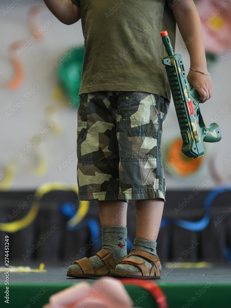 Details with the soldier outfit of a small boy, performing on stage ...