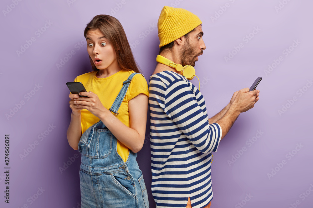 Shocked emotional guy and young woman stand turned backs, surprised ...