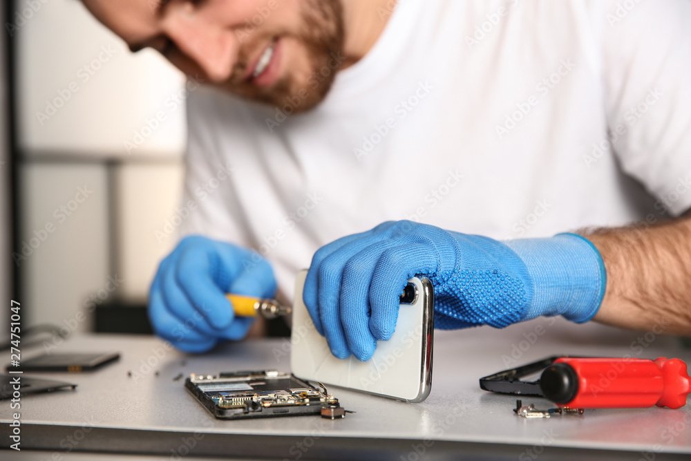 Technician repairing mobile phone at table in workshop, closeup Stock ...