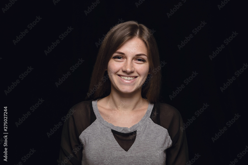 Close up portrait of young woman isolated on black studio background ...