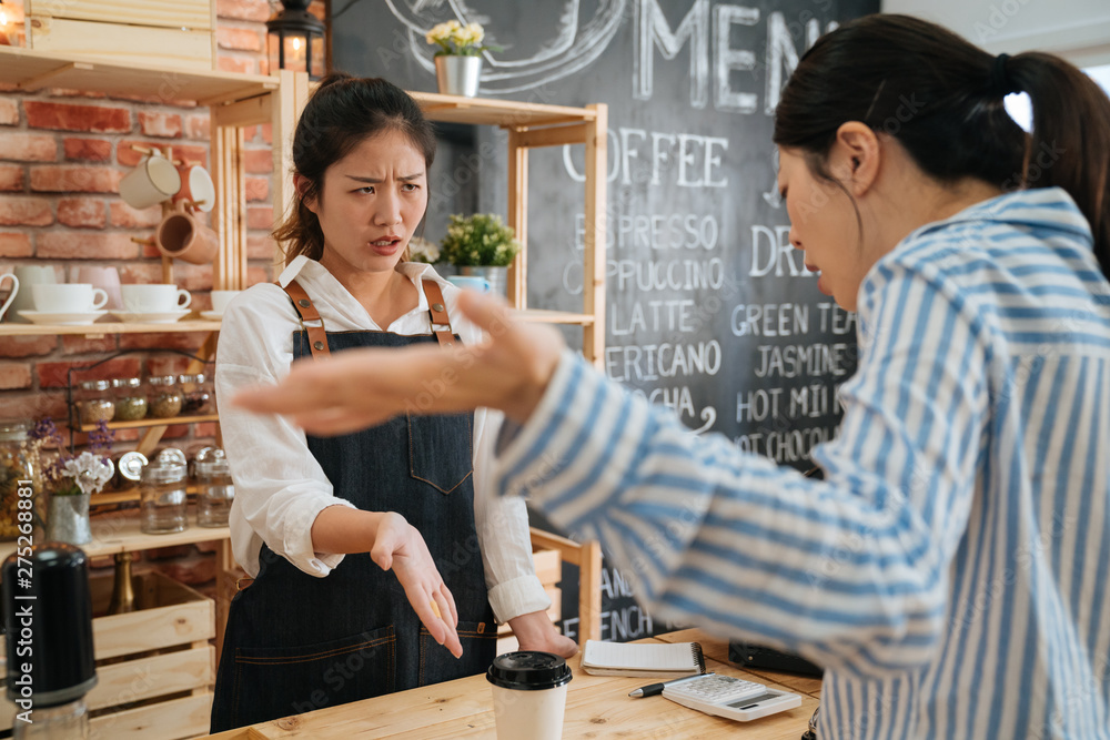 emotional female customer arguing with staff girl at bar counter ...