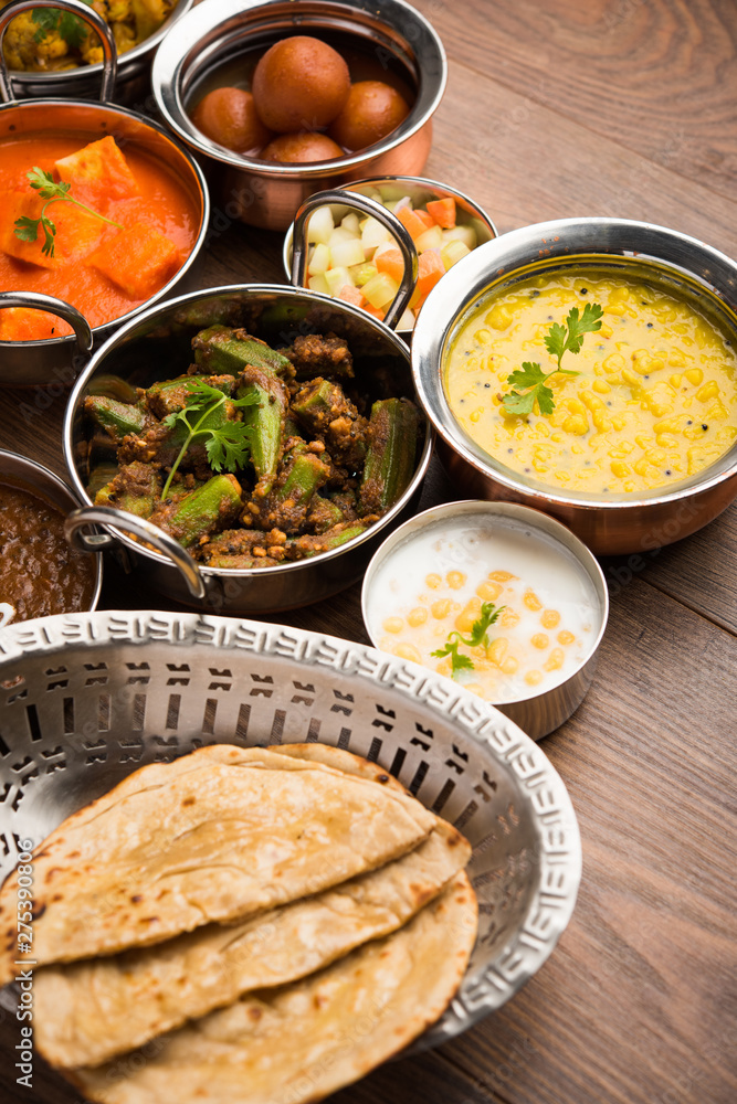 Assorted Indian food like paneer butter masala, dal, roti, rice, sabji ...