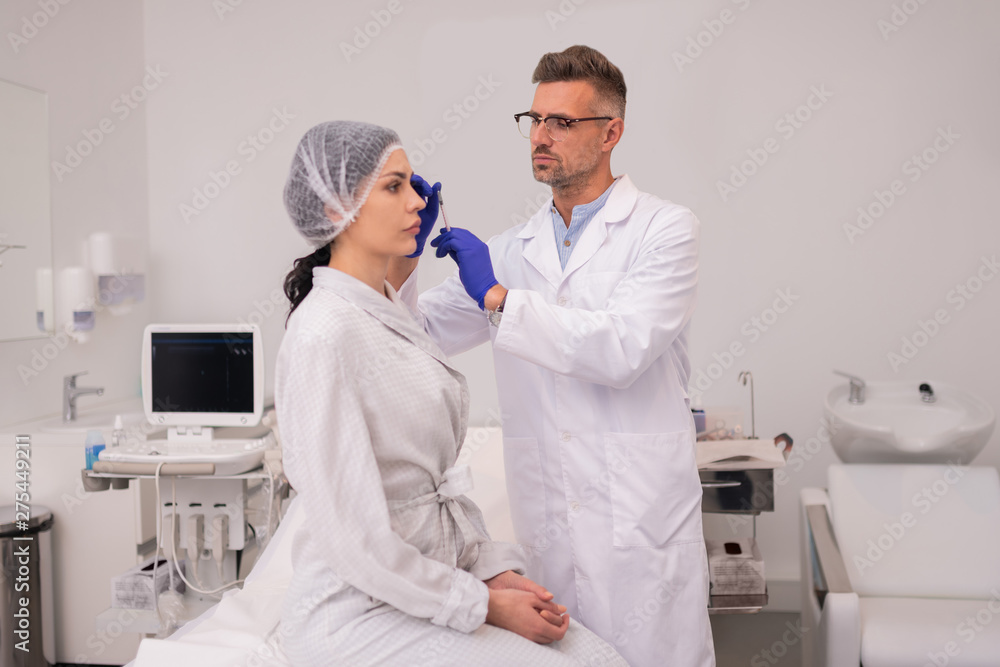 Handsome doctor making botox injections into face for client Stock ...