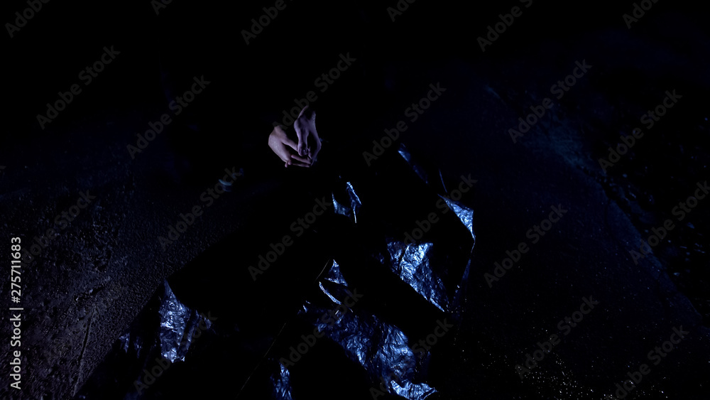 Foto Policeman sitting under body bag with corpse with folding hands ...
